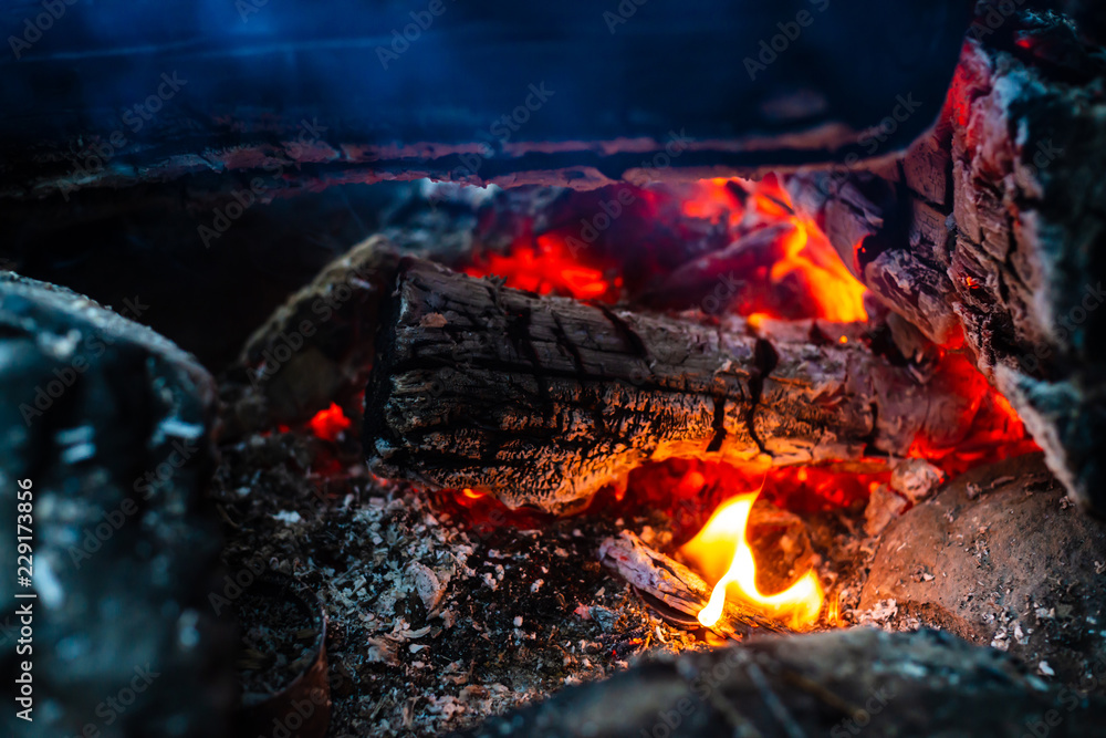 Smoldered logs burned in vivid fire. Atmospheric background with orange ...