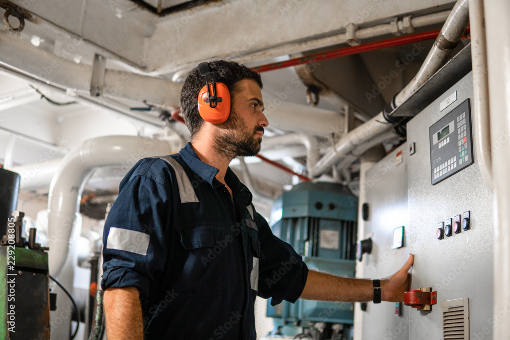 Marine engineer officer in engine control room ECR. Seamen's work. He ...