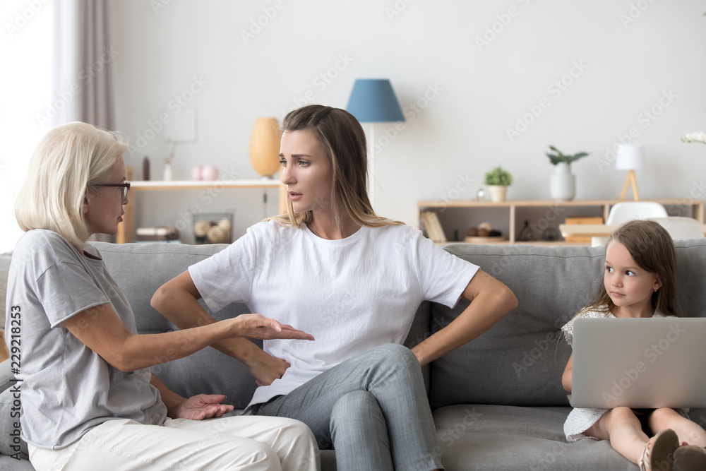 Little girl watch mother and grandmother argue at home, having dispute ...