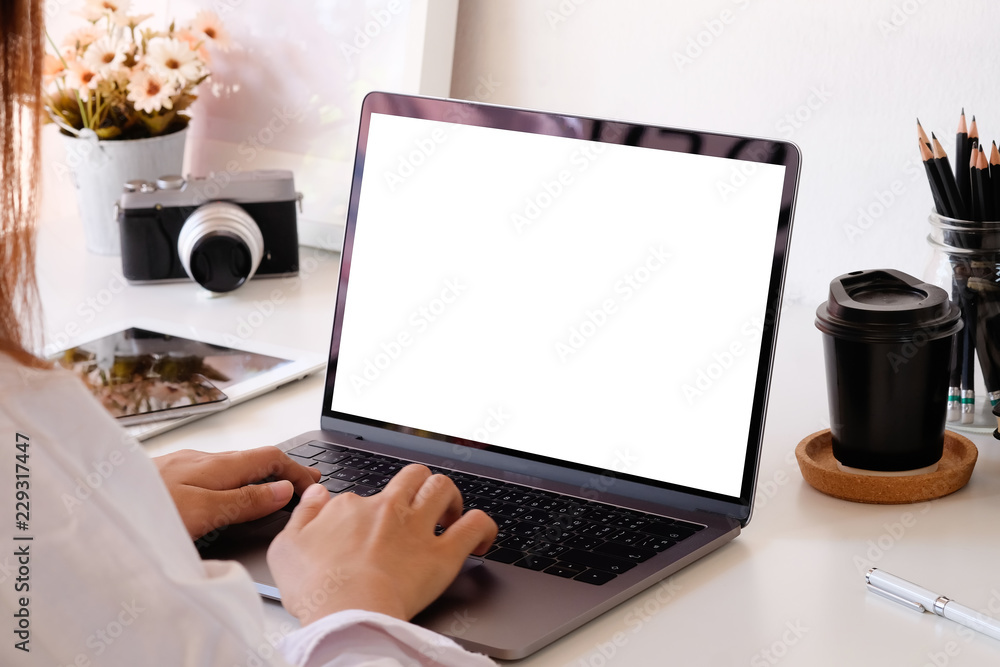 Female woman using mockup laptop computer on office desk, empty display ...