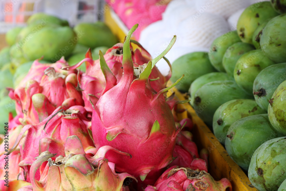 Colourful display of pink dragonfruit also called Pitaya, green mangoes ...