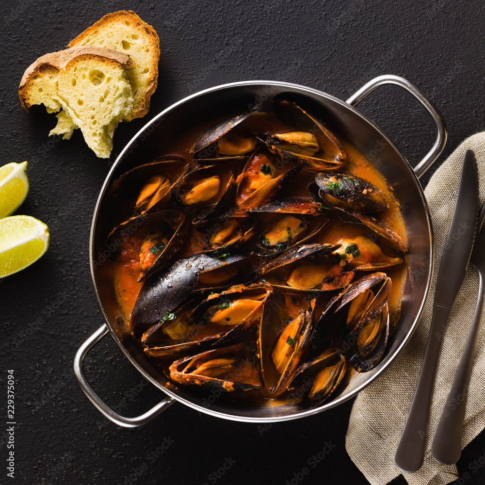 freshly cooked mussels in a frying pan in tomato sauce. pepata di cozze ...
