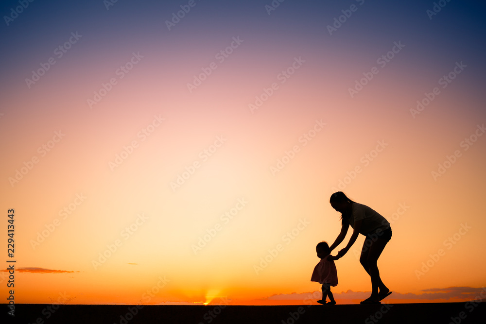 Silhouette of mother teaching her child to walk. Stock Photo | Adobe Stock Silhouette of mother teaching her child to walk. Stock Photo | Adobe Stock