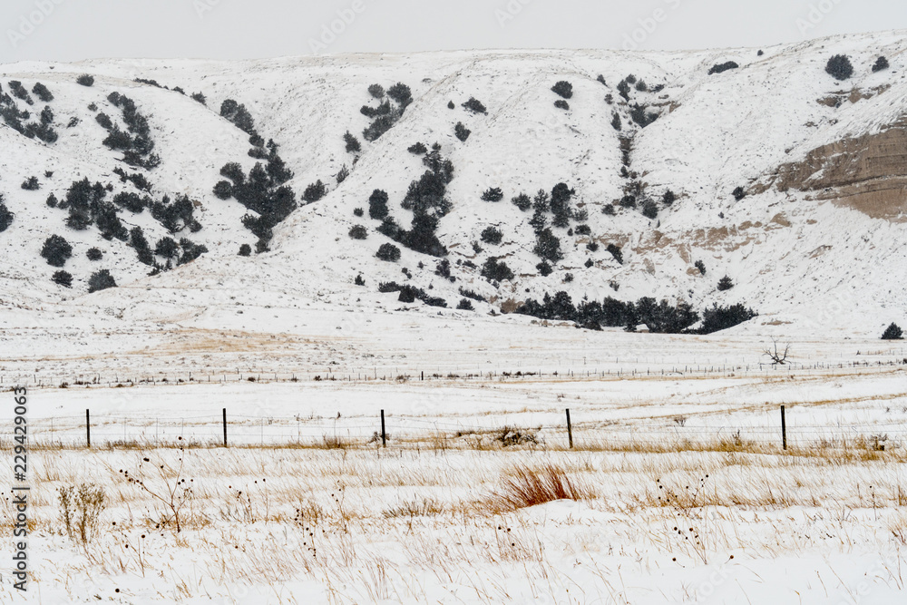 Winter hilly landscape scene in rural Nebraska, with fencing and ...