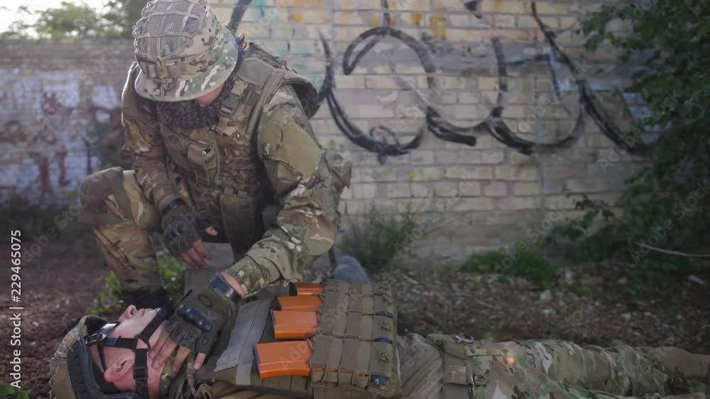 Special forces ranger fully equipped and armed dragging away fallen ...