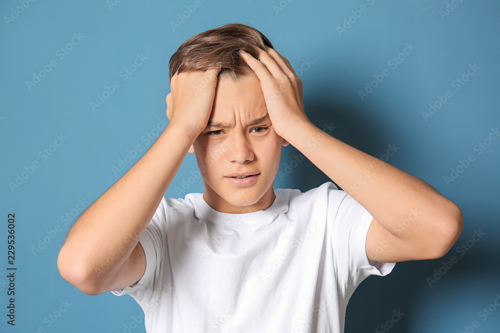 Stressed teenage boy on color background Stock Photo | Adobe Stock
