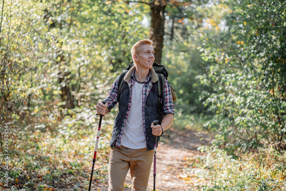 Young man enjoying hiking alone with nordic walking sticks in the ...