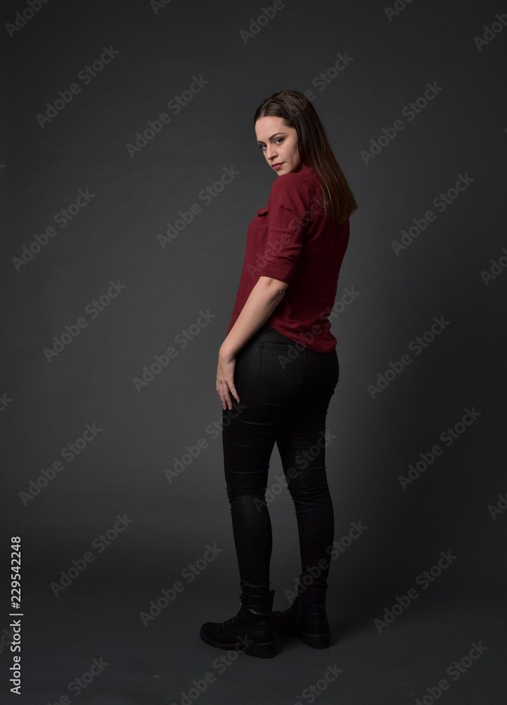 Full Length Portrait Of Brunette Girl Wearing Red Shirt And Leather