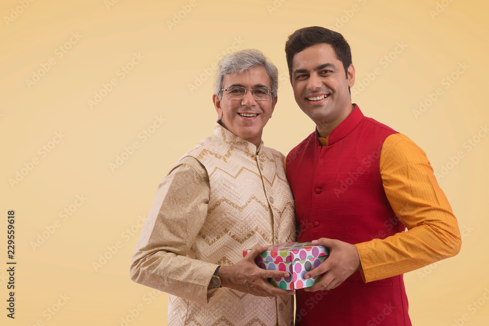 Father giving his son a gift in traditional dress Stock Photo | Adobe Stock