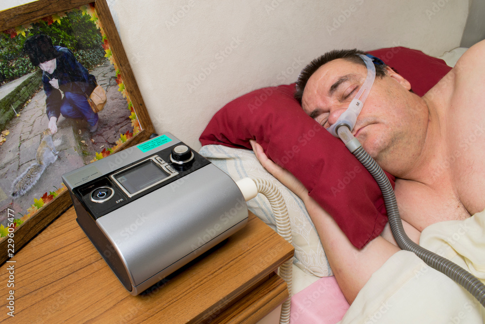 Foto de Man using CPAP Machine and Sleeping Mask for Treatment of Sleep ...