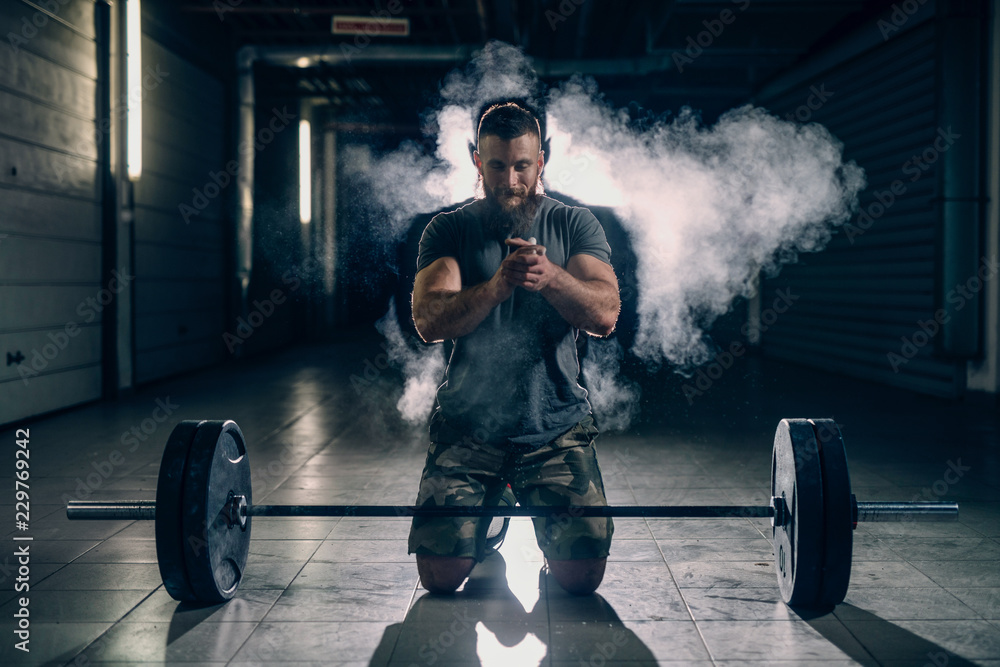 Muscular attractive caucasian bearded man smiling, kneeling, clapping ...