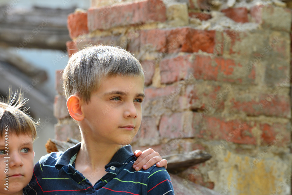 Two brothers stand near the ruined house, the concept of natural ...