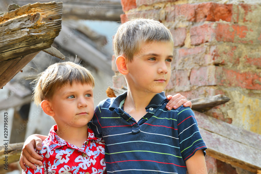 Two brothers stand near the ruined house, the concept of natural ...