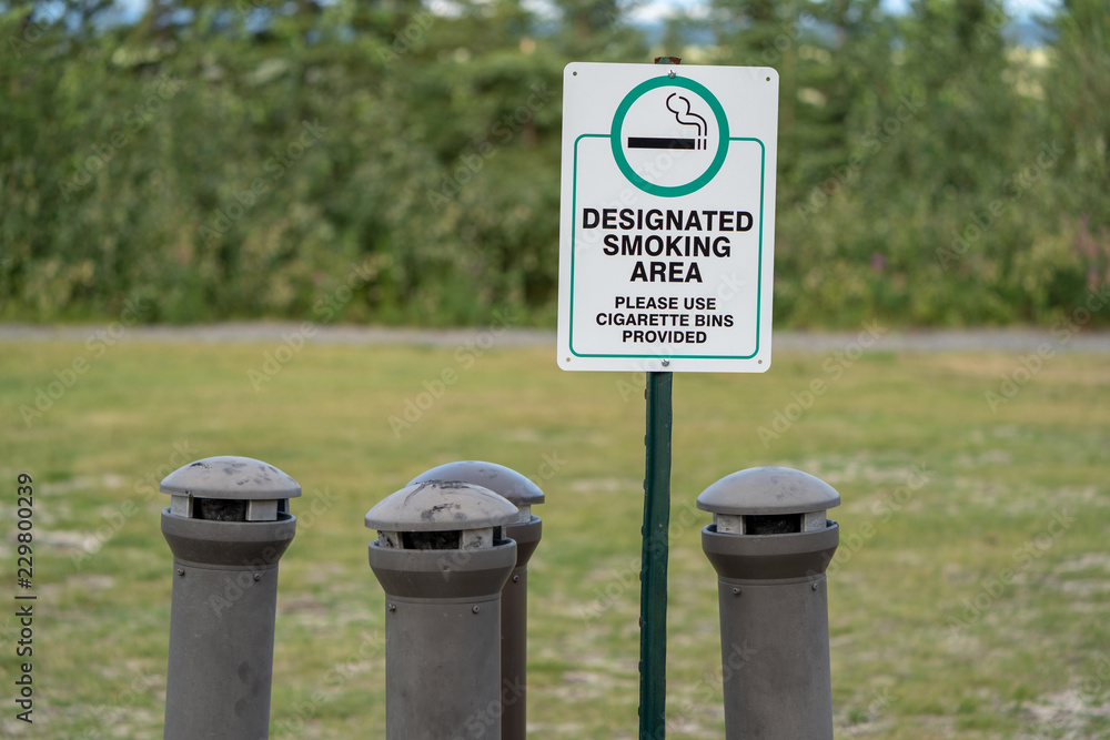 Sign for a designated smoking area with cigarette bins ashtrays Stock ...