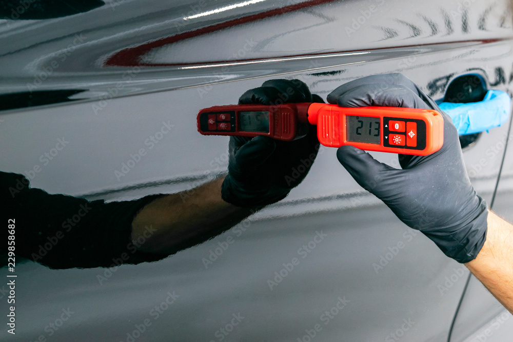 Male hand holds device for measuring coating thickness before polishing ...
