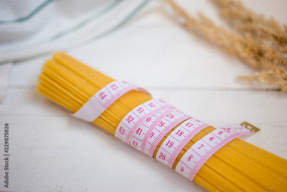 Foto de Measuring tape with bunch of uncooked Italian pasta spaghetti ...