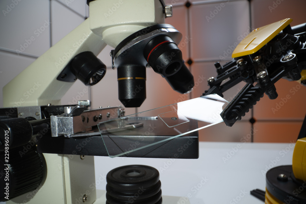 Microscope slide in robot arm and science microscope Stock Photo ...