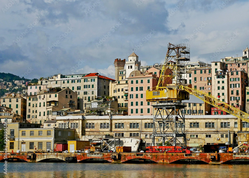 The industrial port of the city of Genoa with the old houses of the ...