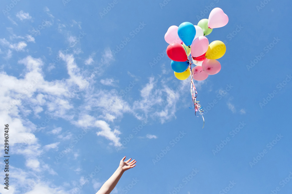 Hand letting balloons fly up in the sky Stock Photo | Adobe Stock