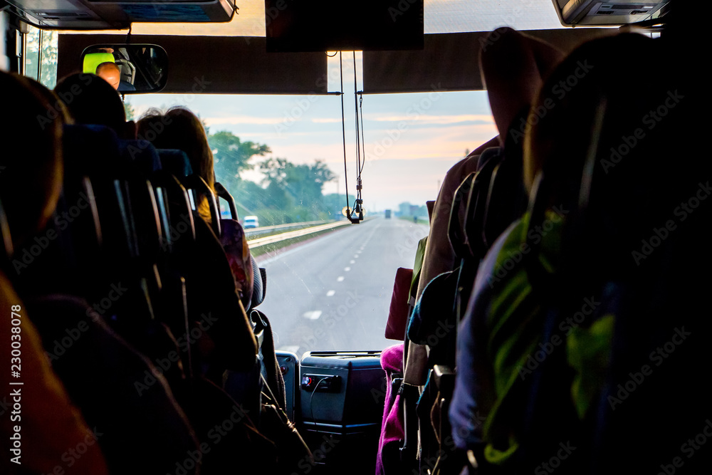 Saloon of bus with passengers. The light of the sun penetrates through ...