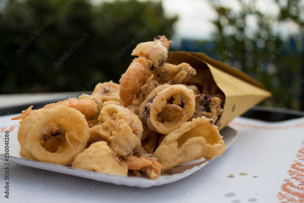 Fritto misto fried fish close up, in brown paper cone; italian street ...