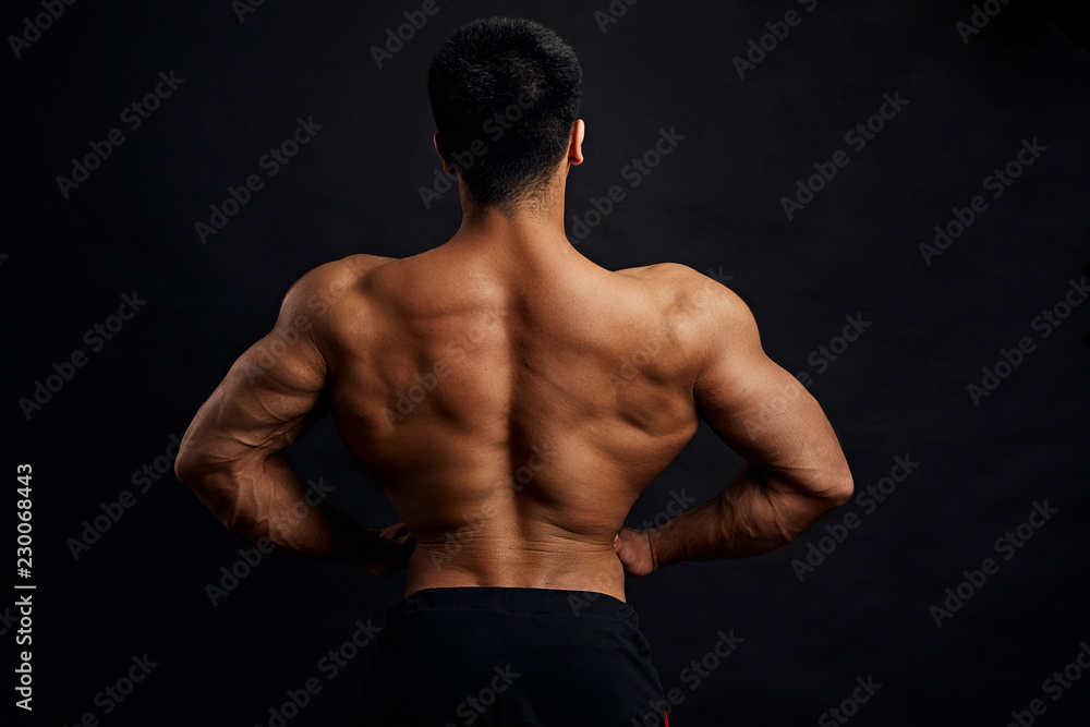 well-built man is fond of bodybuilding. back view photo. copy space ...