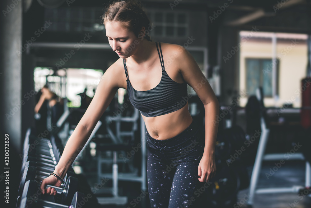 Cinematic tone of young attractive fitness woman exercise with dumbbell ...