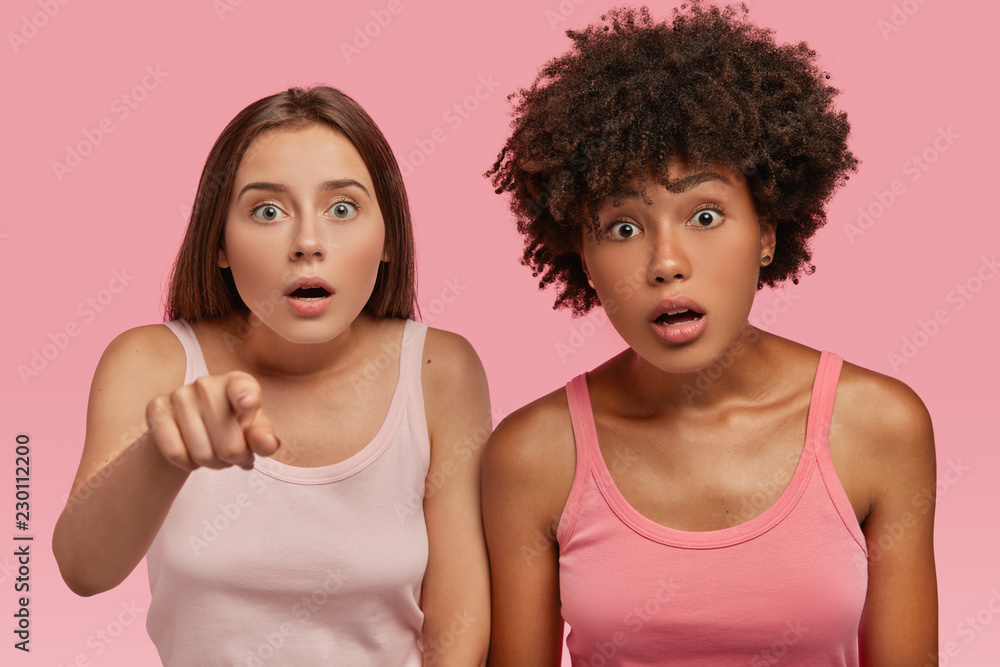 Foto de Emotional mixed race women have shocked gaze directly at camera ...