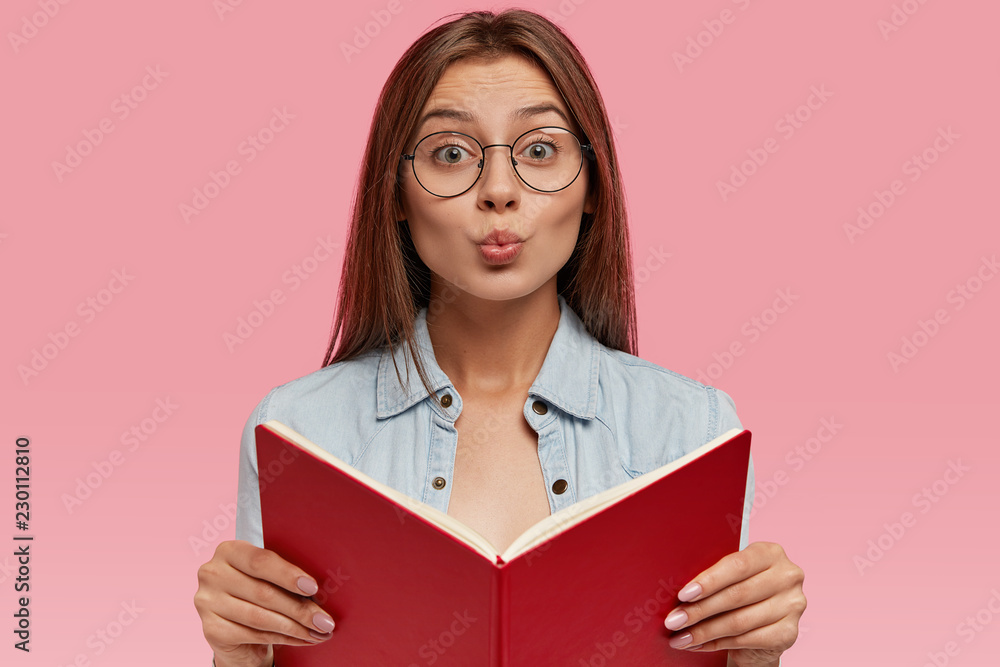 Image of pleasant looking young lady pouts lips at camera, makes ...