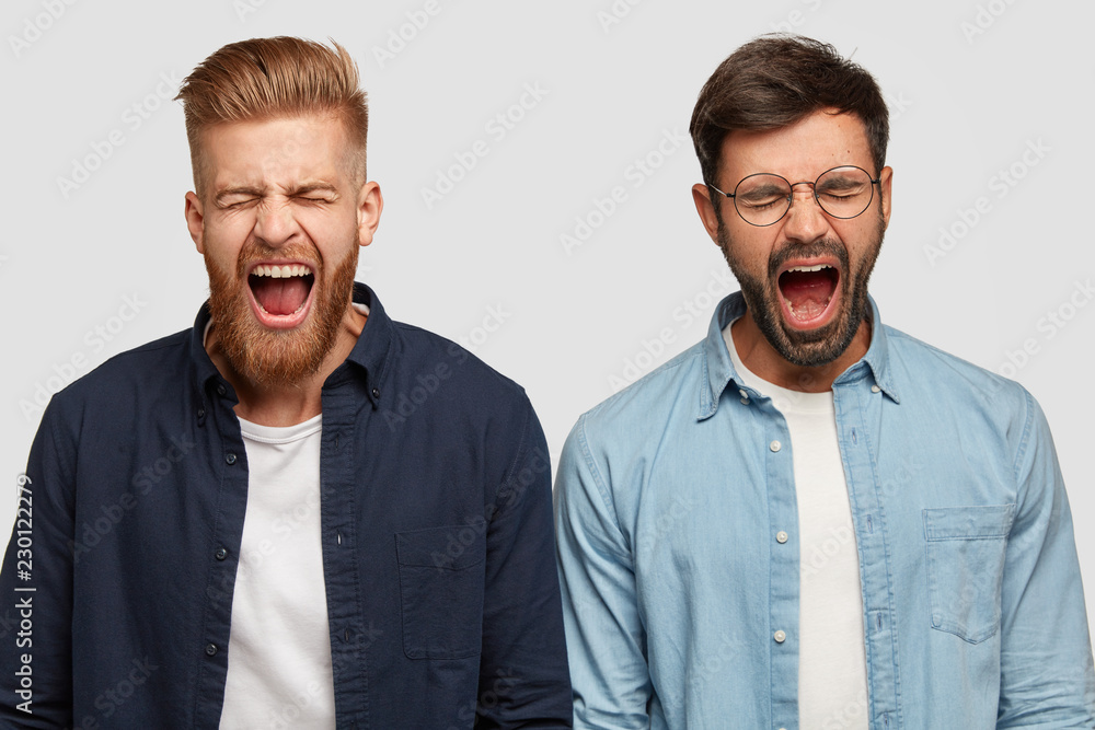 Photo of annoyed guys produce loud yell, open mouth widely, have trendy ...