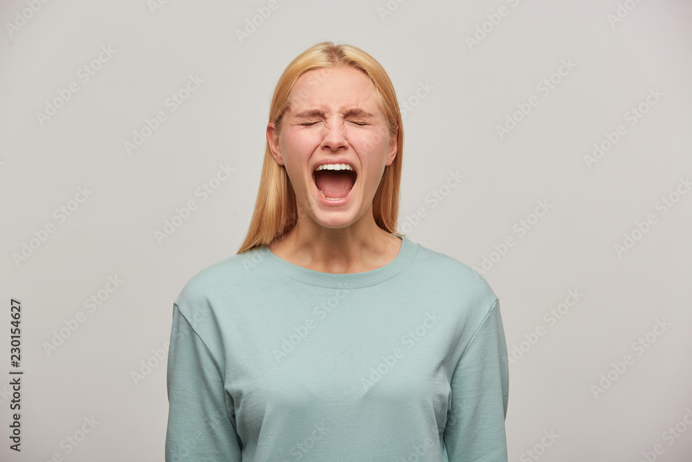 Screaming blonde girl looks frightened afraid imitate scream shout ...