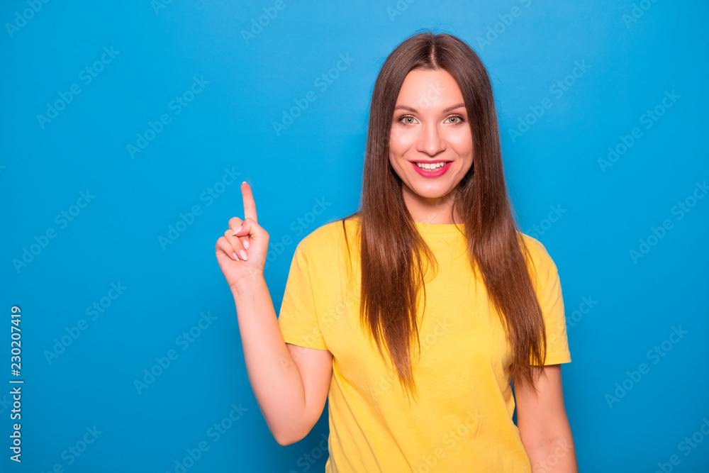 Foto de Cute brunette woman with long hair posing in yellow t-shirt on ...