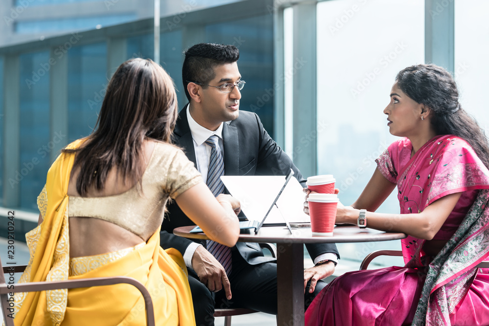 Three Indian business people with worried facial expression talking ...