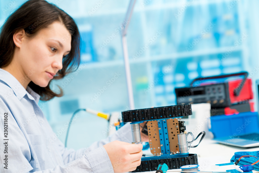 Student girl in electronics laboratory, experiment with microcontroller ...