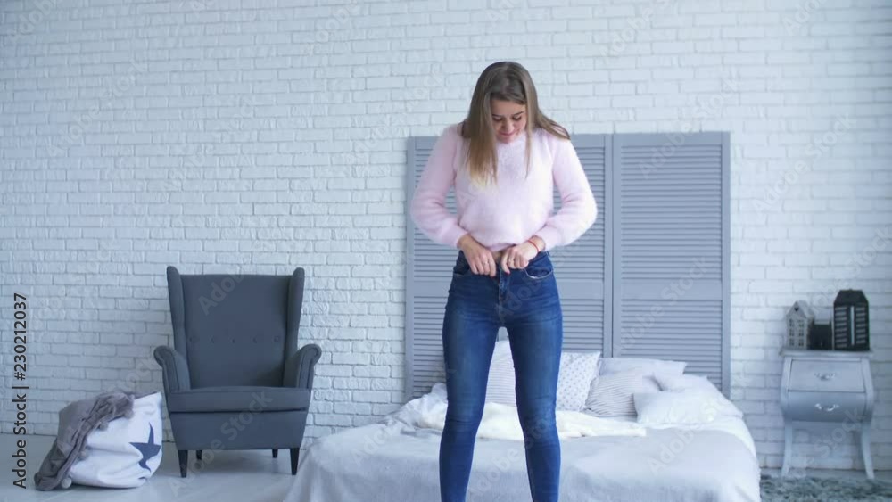 Beautiful Adult Woman Trying To Squeeze Into Old Pair Of Jeans In