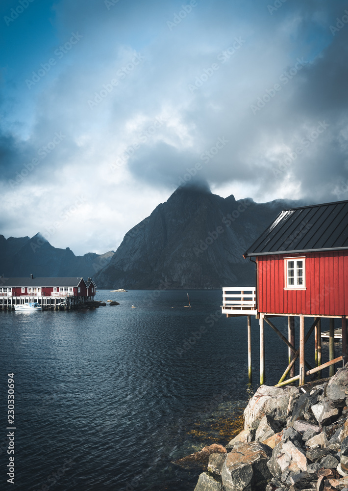 Rainbow ofer red houses rorbuer of Reine in Lofoten, Norway with red ...