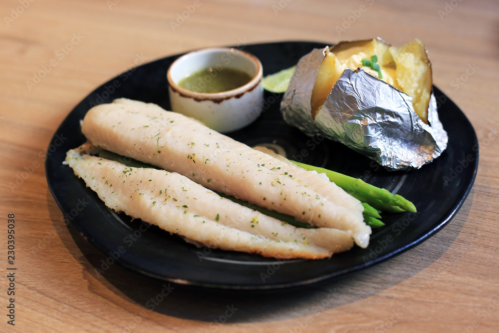 Prepared grilled basa fish fillet with baked potatoes and seafood ...