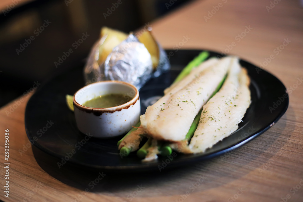 Prepared grilled basa fish fillet with baked potatoes and seafood ...