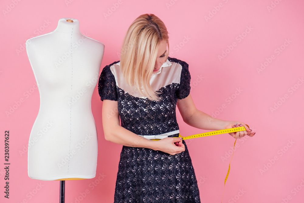 sewing pattern,sewing machine and maniken in studio pink background ...