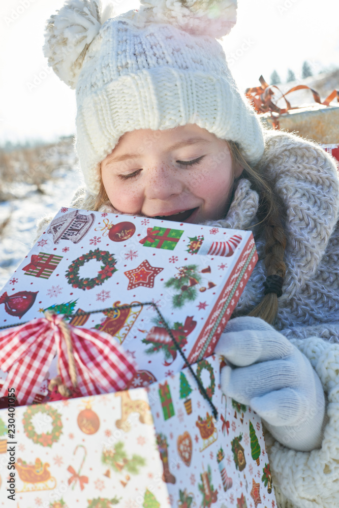 Mädchen packt neugierig Geschenke aus Stock Photo | Adobe Stock