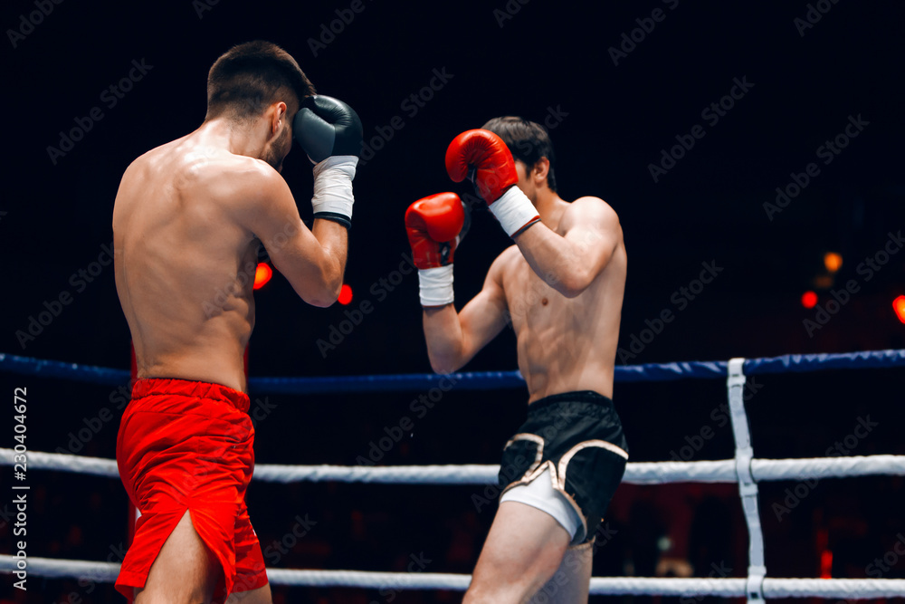 Two professional boxers, athletes in dynamic boxing action on the ring ...