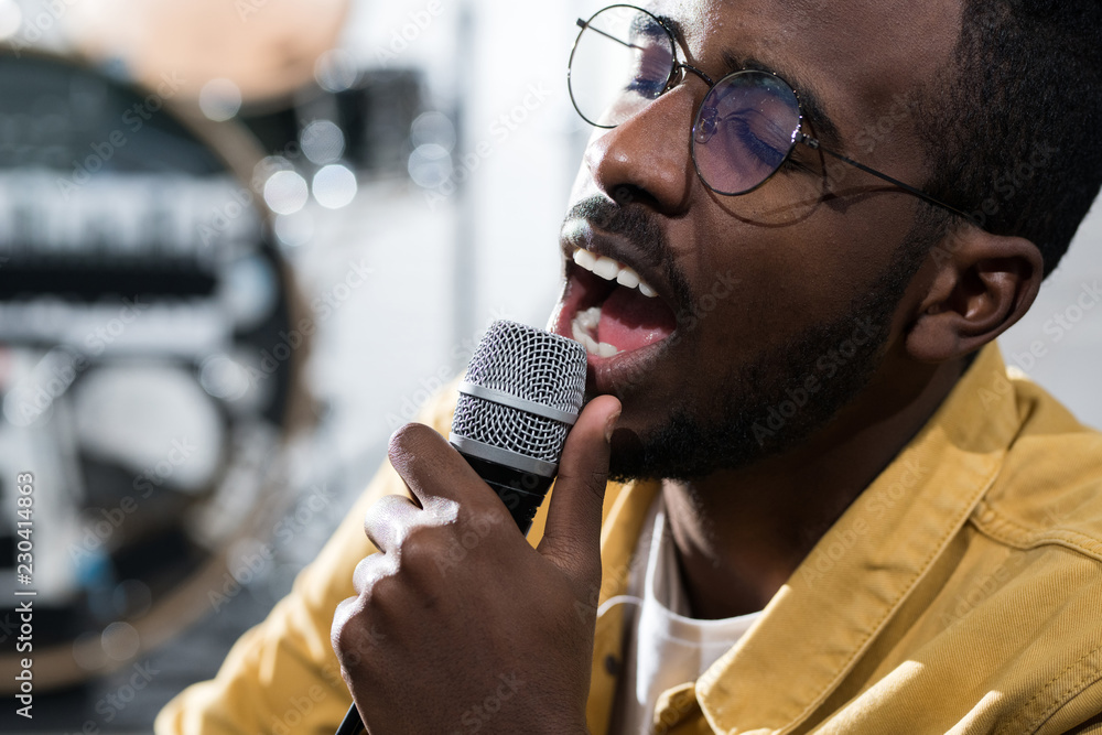 Head and shoulders portrait of inspired African-American man singing to ...