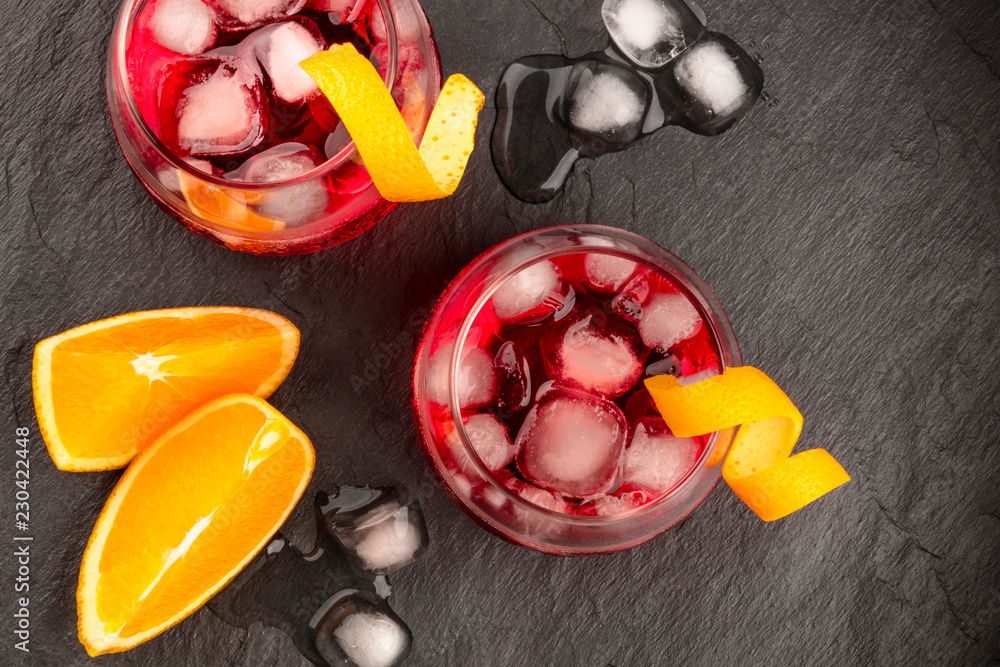 Two vibrant Negroni cocktails with campari and twisted orange zest ...
