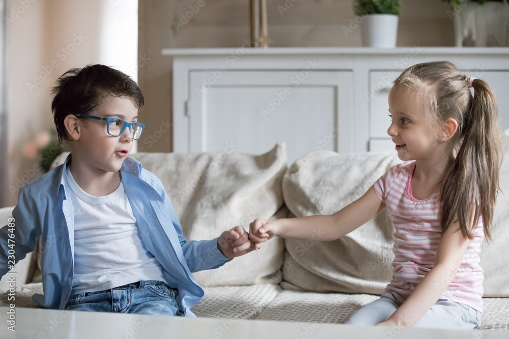 Adorable preschool kids sitting on sofa at home. Little children ...
