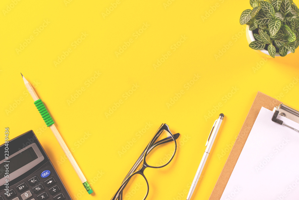 Top view of creative workspace with stationery supplies on yellow ...