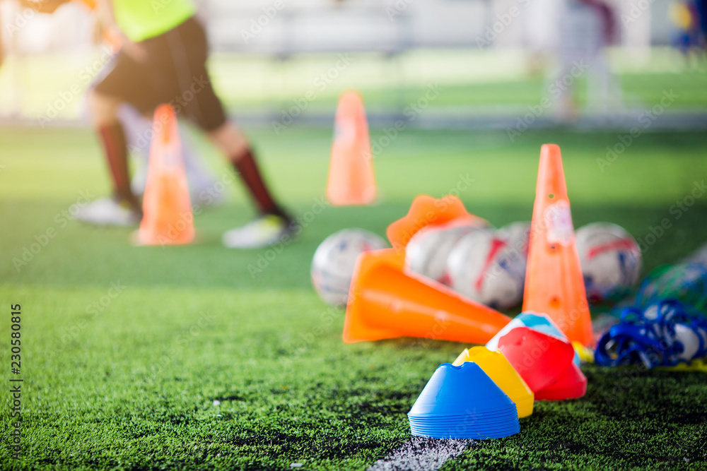 Football and soccer training equipment on green artificial turf with ...