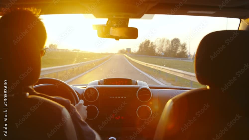 Person drive the car towards the sunset in slow motion 4K. Static long ...