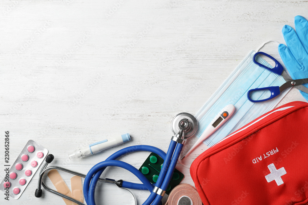 Flat lay composition with first aid kit and space for text on wooden ...