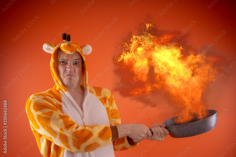 Emotional guy holding a frying pan in his hands, on an orange ...