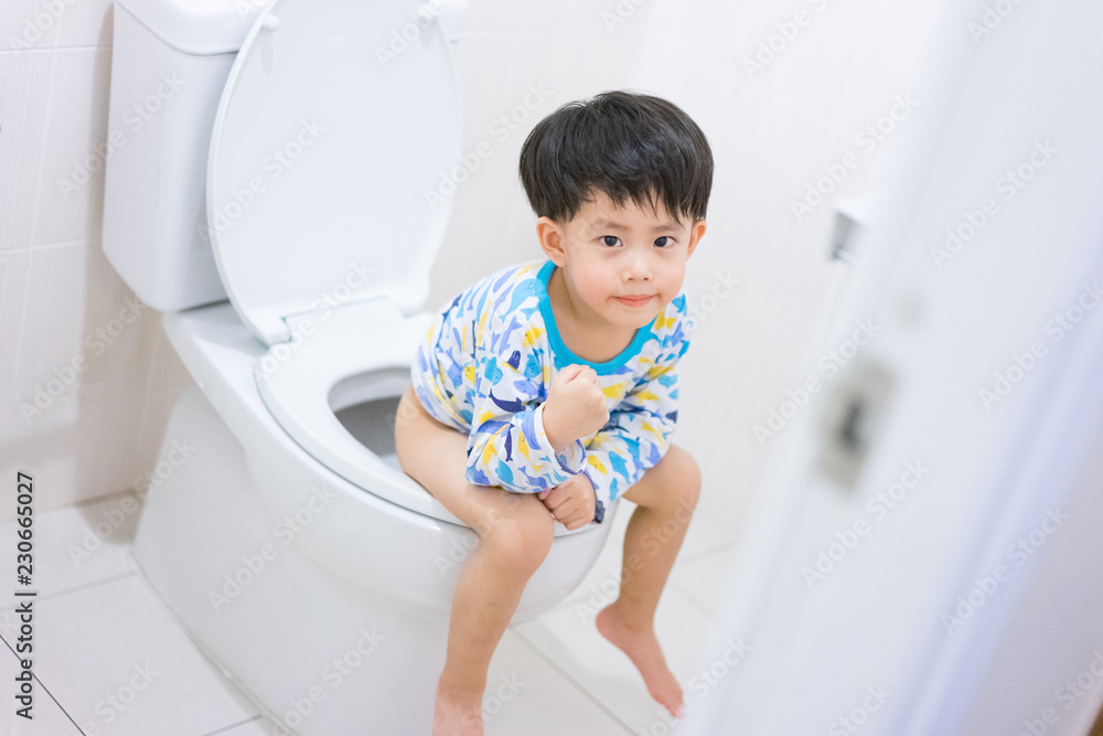 Little boy poo and pee in white toilet. Stock Photo | Adobe Stock